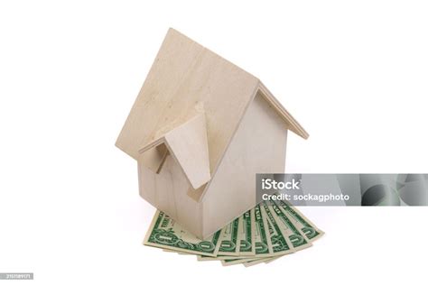 흰색 바탕에 고립된 부동산 투자를 지원하는 돈을 묘사하는 집의 나무 모형 아래 달러 지폐 부채 0명에 대한 스톡 사진 및 기타