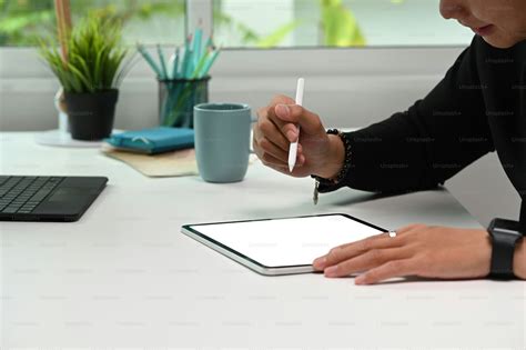 그래픽 디자이너가 흰색 책상에 디지털 태블릿으로 사진을 편집하는 장면을 자릅니다 사진 Unsplash의 그래픽 디자이너 이미지