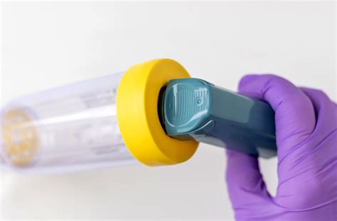 천식 흡입기 및 에어로졸 공간 주사기 청진기 또는 치과 의사 도구 Mirrordoctor 의료 보조 예방 접종 호흡기 감염 치과 치료를 들고 장갑을 낀 손 천식 흡입기에