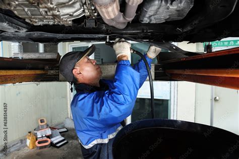동네 카센터에서 리프트에 올려진 자동차 하체를 점검하는 엔지니어 Stock Foto Adobe Stock