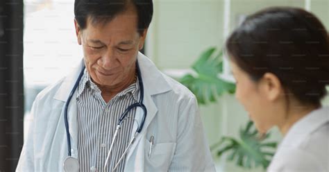 의료용 흰 가운을 입은 중년 남성 전문의가 병원 사무실에서 진단 여성 환자를 검사합니다 사진 Unsplash의 태국 이미지