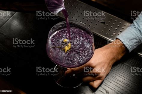 노란 꽃과 큰 칵테일 유리에 보라색 알코올 음료를 부어 바텐더 가죽에 대한 스톡 사진 및 기타 이미지 가죽 각얼음 갈색