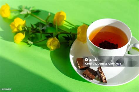 녹색 배경에 홍차 한 잔 초콜릿 조각 트롤리우스 유로파유의 노란 꽃 초콜릿 낮과 아침 차 0명에 대한 스톡 사진 및 기타 이미지 Istock
