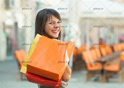 عکس با کیفیت دختر شاد با کیسه های خرید در دست عکس با کیفیت و تصاویر