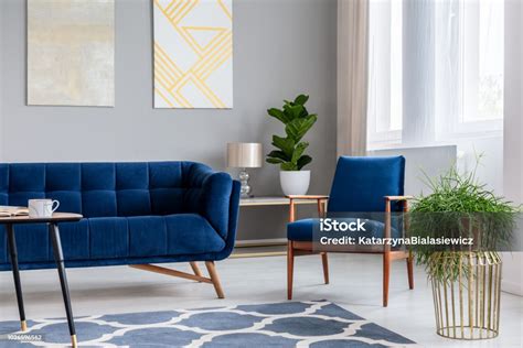 신선한 식물 현대 미술 회화 및 커튼으로 창 밝은 거실 인테리어의 실제 사진에는 소파 옆에 해군 파란 안락의 자 서 거실에 대한