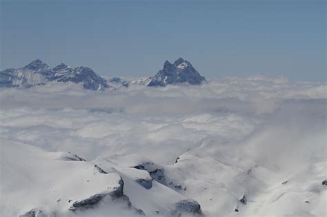 Majestical 현장 풍경 아름 다운 높은 바위와 맑고 푸른 밝은 날에 극적인 흐린 하늘 구름 눈 덮인 봉우리 중간 얼음 산 겨울에 대한 스톡 사진 및 기타 이미지