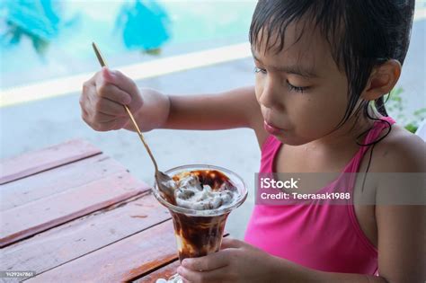 가족 여름 방학 동안 야외 수영장에서 아이스크림을 먹는 수영복에 젖은 어린 소녀 여름 라이프 스타일 개념 6 7 살에 대한 스톡