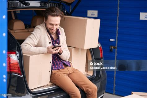 창고에서 자동차 트렁크에 골판지 상자를 들고 웃고 있는 젊은 남자 30 34세에 대한 스톡 사진 및 기타 이미지 30 34세 개념 관세 Istock