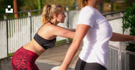 흰색 티셔츠와 검은 치마를 입은 여자가 빨간 꽃 드레스를 입은 여자와 손을 잡고 있다 사진 Unsplash의 무료 운동 이미지