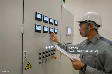 공장에서 상태 고전압 회로 차단기 스위치 기어 배전 변전소를 확인하고 모니터링하기 위해 일하는 전기 유지 보수 기술자 공장 산업 건물에 대한 스톡 사진 및 기타 이미지