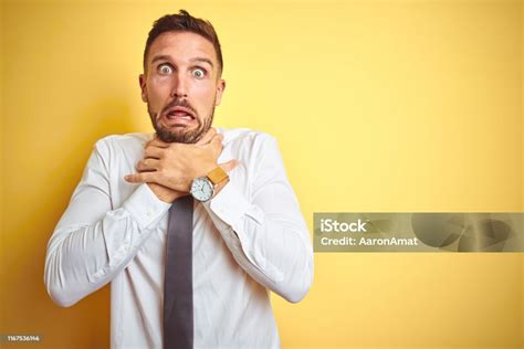 노란색 고립 된 배경 에 우아한 흰색 셔츠를 입고 젊은 잘 생긴 사업가 는 고통스러운 목졸림 때문에 외치고 질식 건강 문제 질식 과 자살 개념 건강한 생활방식에 대한 스톡