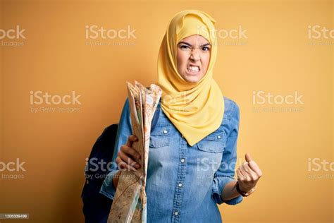 무슬림 히잡과 배낭을 들고 휴가에 젊은 관광 소녀는 성가신 과 좌절 분노와 함께 외치고 미친 소리와 함께 고함 제기 손으로 분노 개념 감정에 대한 스톡 사진 및 기타 이미지