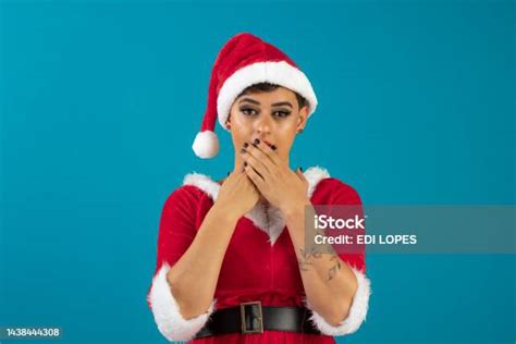 산타클로스 복장과 모자를 쓴 젊은 여성 파란색 배경과 크리스마스 테마가 있는 스튜디오 사진 12월에 대한 스톡 사진 및 기타 이미지 Istock