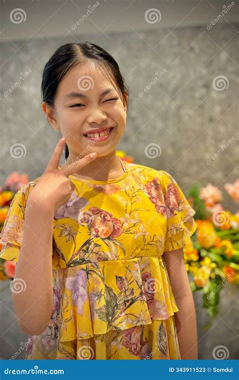 Portrait Of A Beautiful Asian Preteen Girl In A Floral Dress Posing