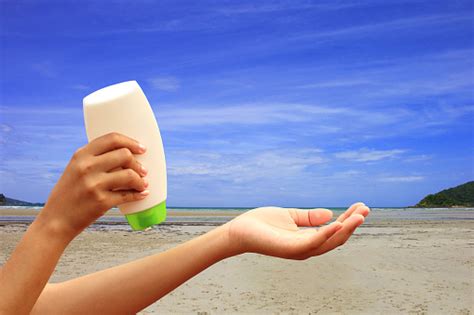푸른 하늘 배경 Spf 자외선 보호 및 피부 케어 개념에서 바다와 해변에서 자외선 차단제를 들고 여자 손 Fashion Show