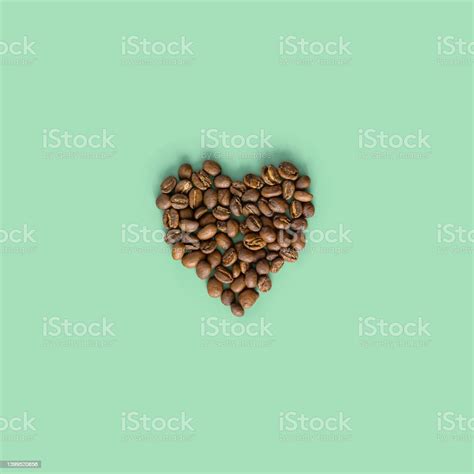 커피 원두에서 커피 백과 심장을 떨어 뜨리고 컵에서 양조하기위한 분쇄 커피 종이 봉지 드립 커피 필터 민트 색상 배경 상단보기