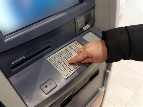 close up of hand entering pin pass code on atm bank machine keypad