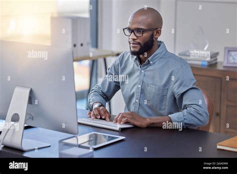Sending Out Emails A Young Businessman Using A Computer In An Office