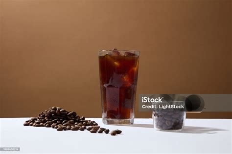 갈색 배경에 커피와 커피 원두의 컵의 정면도입니다 음료 제품의 광고 장면 커피에 함유된 활성 카페인은 정신을 차리고 상쾌하며 집중력을 높여줍니다 0명에 대한 스톡 사진 및