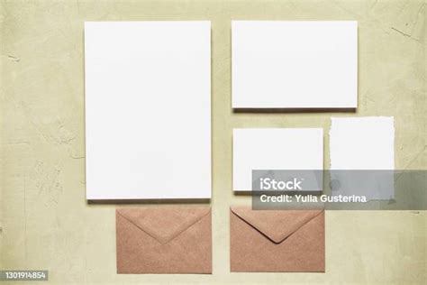 베이지 색 콘크리트 배경에 빈 종이 흰색 카드 모형과 갈색 공예 봉투 현대 문구는 여전히 생활 디자인용 템플릿입니다 상단 보기 플랫 레이 봉투에 대한 스톡 사진 및 기타