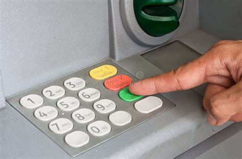 close up of hand entering pin pass code on atm bank machine keypad