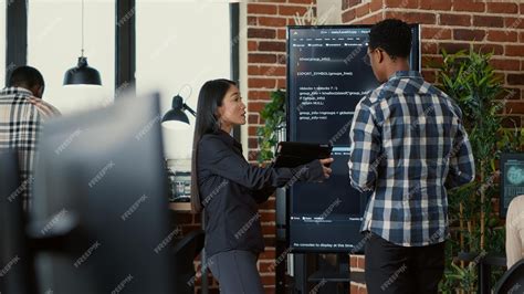 Free Photo Team Of Coders Analyzing Code On Wall Screen Tv Comparing