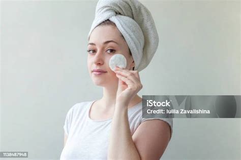 흰색 배경에 고립 된 면 패드를 사용 하 여 부드러운 건강 한 피부 제거와 머리에 수건에서 웃는 여자 건강한 생활방식에 대한 스톡 사진 및 기타 이미지 Istock