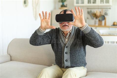 Excited Mature Senior Man Wearing Using Virtual Reality Metaverse Vr Glasses Headset At Home