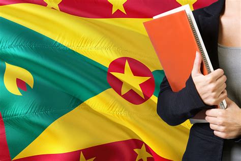 학습 Grenadian 언어 개념입니다 백그라운드에서 그레나다 국기와 함께 서 있는 젊은 여자 책을 들고 교사 오렌지 빈 책