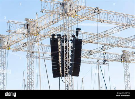 array of professional line array speakers suspended from a metal truss