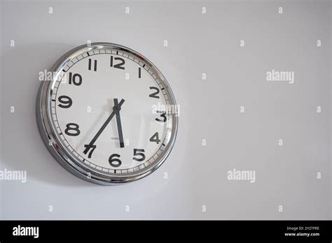 Round Analog Clock Hanging On White Wall Shows Clean And Modern Style With Functional Design Round Analog Clock Hanging On White Wall Shows Clean And Modern Style With Functional Design