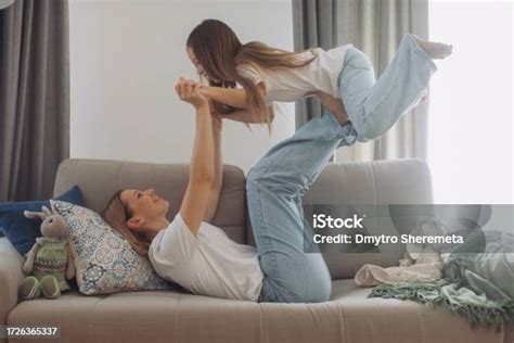 젊은 엄마와 딸은 집에서 즐거운 시간을 보낸다 어머니는 거실 소파에서 딸과 놀고 주말을 함께 보낸다 아이에 대한 스톡 사진 및 기타 이미지 Istock