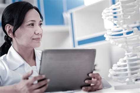 Joyful Female Scientist Examining Three Dimensional Model Of Dna Stock