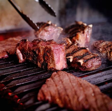 Una Persona Asando Carne A La Parrilla Foto Premium