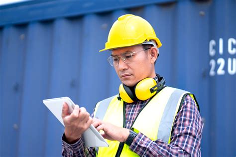 적재를 위해 콘테이너에 재고를 검사하는 정제 컴퓨터를 사용하는 직업적인 엔지니어 콘테이너화물 45 49세에 대한 스톡 사진 및 기타 이미지 Istock