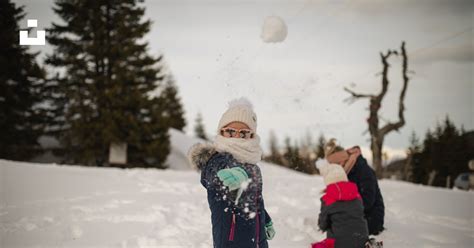 분홍색 재킷과 분홍색 바지를 입은 소녀는 낮에 눈 덮인 땅에 서 있습니다 사진 Unsplash의 무료 카취베르크 이미지