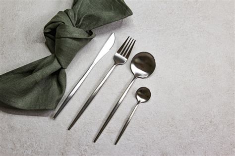 회색 돌 배경에 녹색 섬유 냅킨과 칼 숟가락과 포크 테이블 설정입니다 맨 위 보기입니다 0명에 대한 스톡 사진 및 기타 이미지