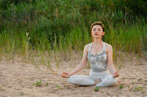 연꽃에서 밖에서 요가를 연습하는 여자는 모래 위에서 포즈를 취한다 건강한 생활방식에 대한 스톡 사진 및 기타 이미지 건강한