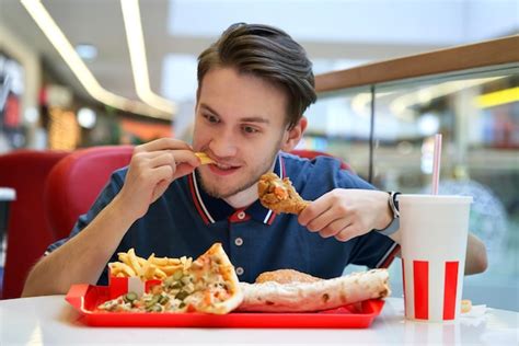 Joven Comiendo Comida Rápida En El Centro Comercial En El Patio De
