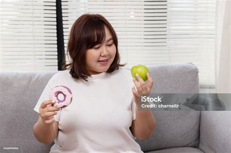 과체중 아시아 여성은 건강을 위해 도넛보다는 녹색 사과를 먹기로 선택합니다 고름에 대한 스톡 사진 및 기타 이미지 고름 과일 과체중 Istock