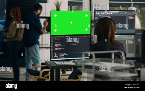 Software Developer Analyzing Greenscreen And Server Code On Multiple Monitors In Busy Ai