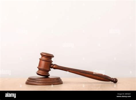 Judge's gavel on table against light background Stock Photo - Alamy