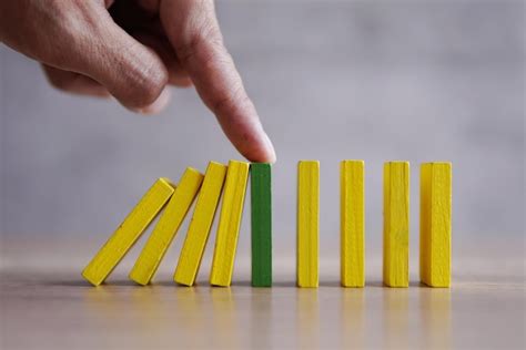Premium Photo Finger Stopping Domino Effect Risk Management