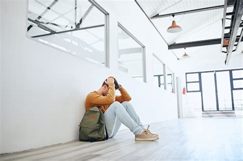 청년 정신 건강 및 스트레스 학생 우울하고 빈 방에서 머리를 들고 바닥에 있습니다 소진 남성 두려움 사회적 불안에 좌절하고 피곤하고 과로하고 무서워합니다 학생에 대한 스톡