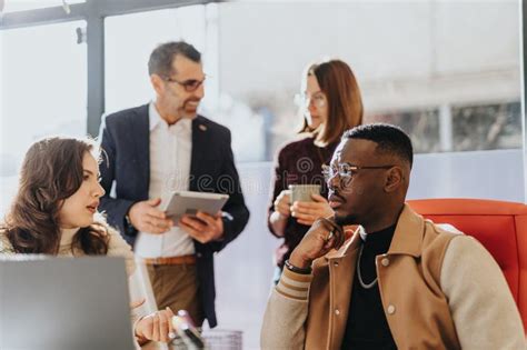 A Group Of Coworkers Collaborating And Discussing Project Details In An