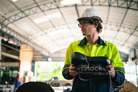 산업 공장에서 자동 로봇 기계를 점검 및 수리하는 로봇 컨트롤러를 들고 있는 전문 엔지니어 제조 생산을 위해 로봇 팔 시스템으로 작업하는 기술자 25 29세에 대한 스톡