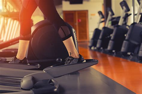 아침에 건강 한 라이프 스타일을 슬림 하 고 회사에 대 한 에어로빅 기계 체중 감량을 복용 하는 여자의 피트 니스 체육관에서 운동을 실행 하는 타원형 심장 운동 가냘픈에