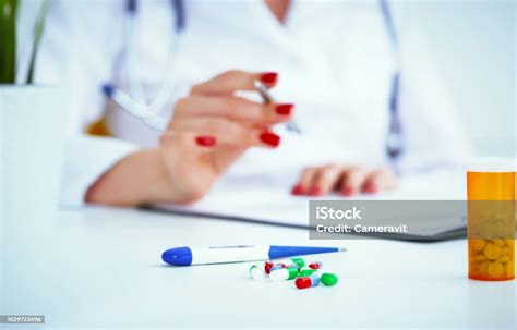 약 그리고 전자 온도계 배경에서 작업 하는 여성 의학 의사와 테이블에 누워 의학 의사는 환자에 게 약을 처방 의료 및 의료 개념 건강 진단에 대한 스톡 사진 및 기타 이미지