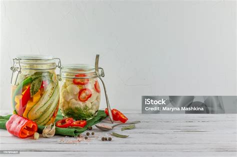 밝은 배경에 발효 콜리플라워 오이 양파 야채의 두 유리 항아리 섬유 녹색을 사용하여 발효는 프로바이오틱스의 공급원입니다 인기있는 채식 음식 복사 공간 0명에 대한 스톡 사진