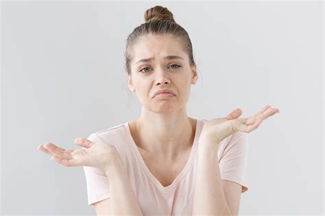 마치 그녀가 현재 상황을 어떻게 해야할지 모르는 손실에 회색 배경에 고립 된 감정적인 젊은 여자의 근접 촬영 곡선 팔과 손 입 력한 제스처를 보여주는 거절에 대한 스톡 사진